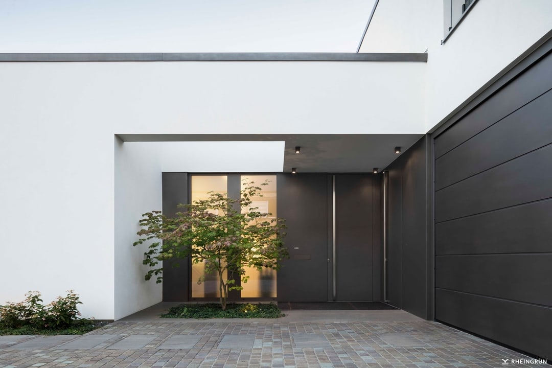 Villa mit Flachdach, großer Rasenfläche und akzentuierter Bepflanzung ...